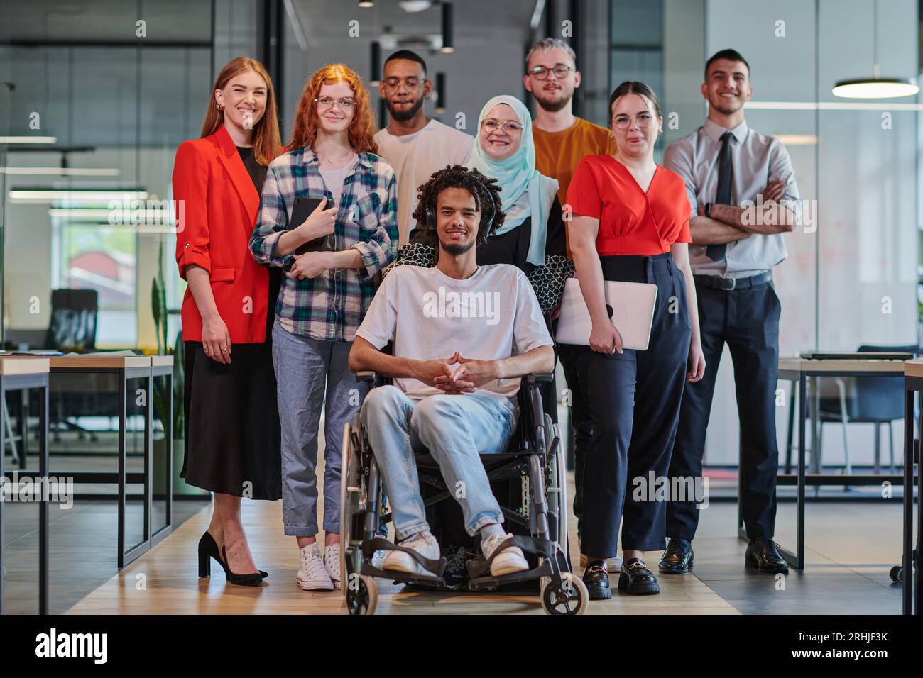 A diverse group of young business people congregates within a modern ...