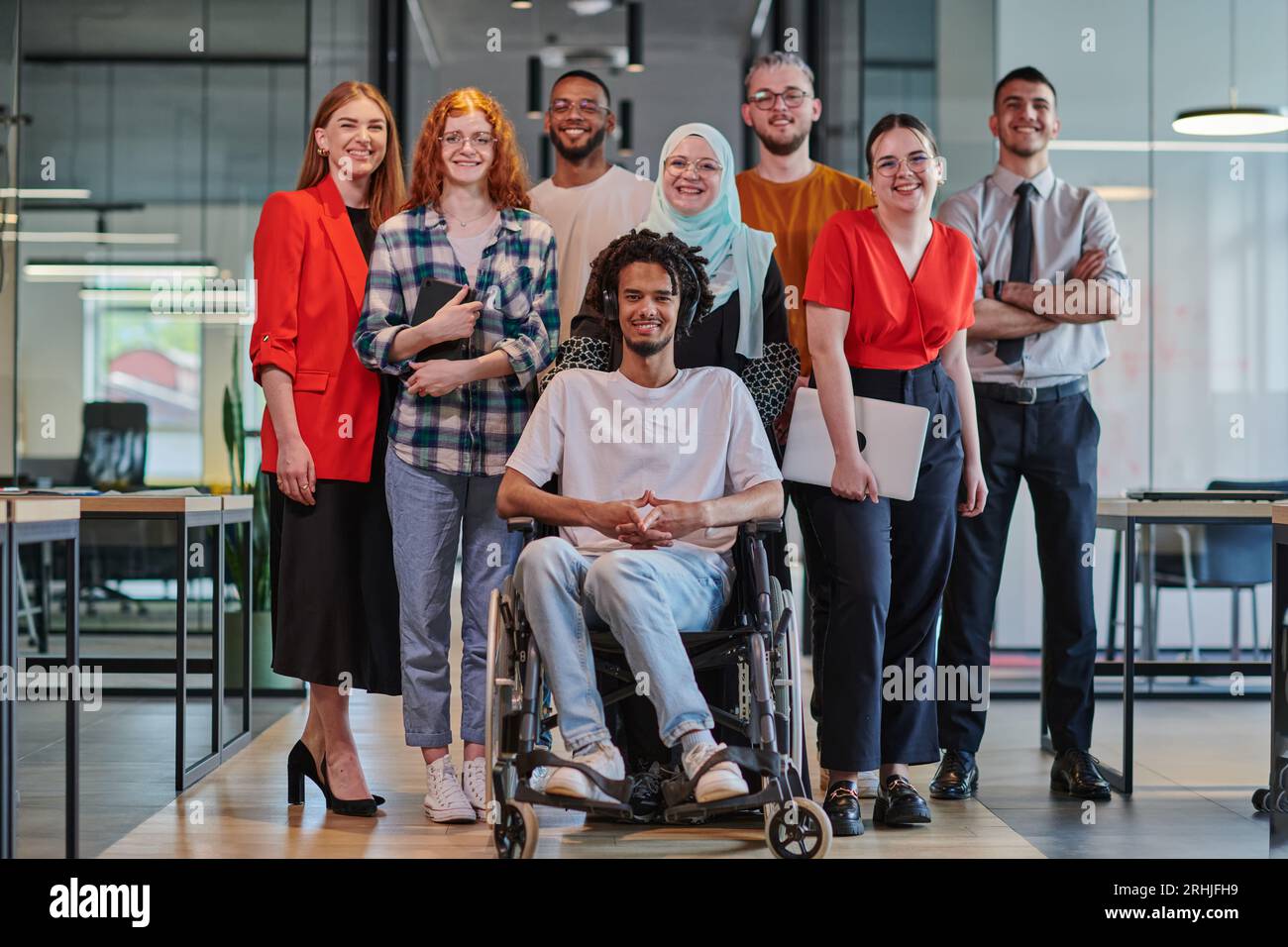 A diverse group of young business people congregates within a modern ...