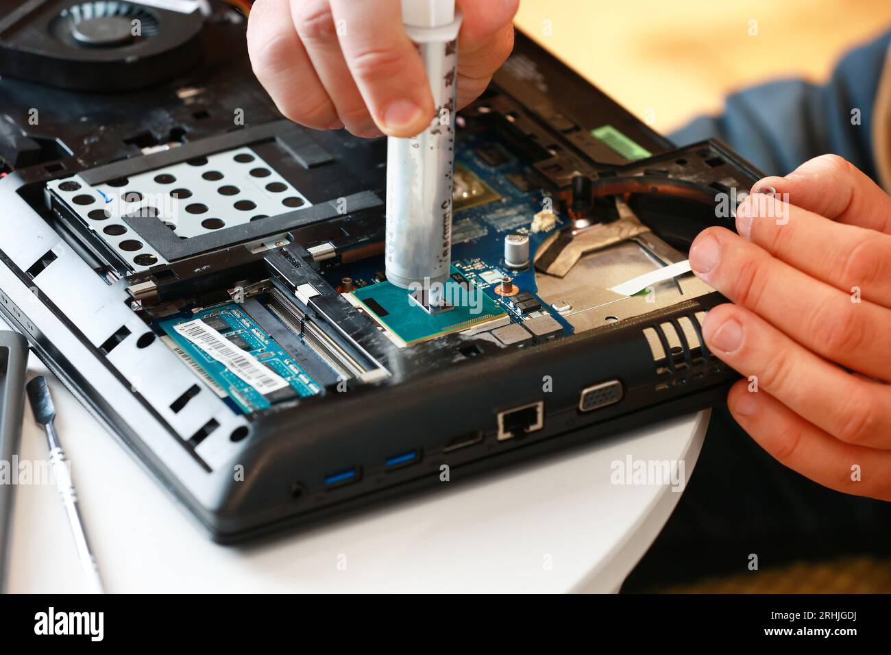 Hand a repairman uses thermal paste syringe apply thermal compound to a ...
