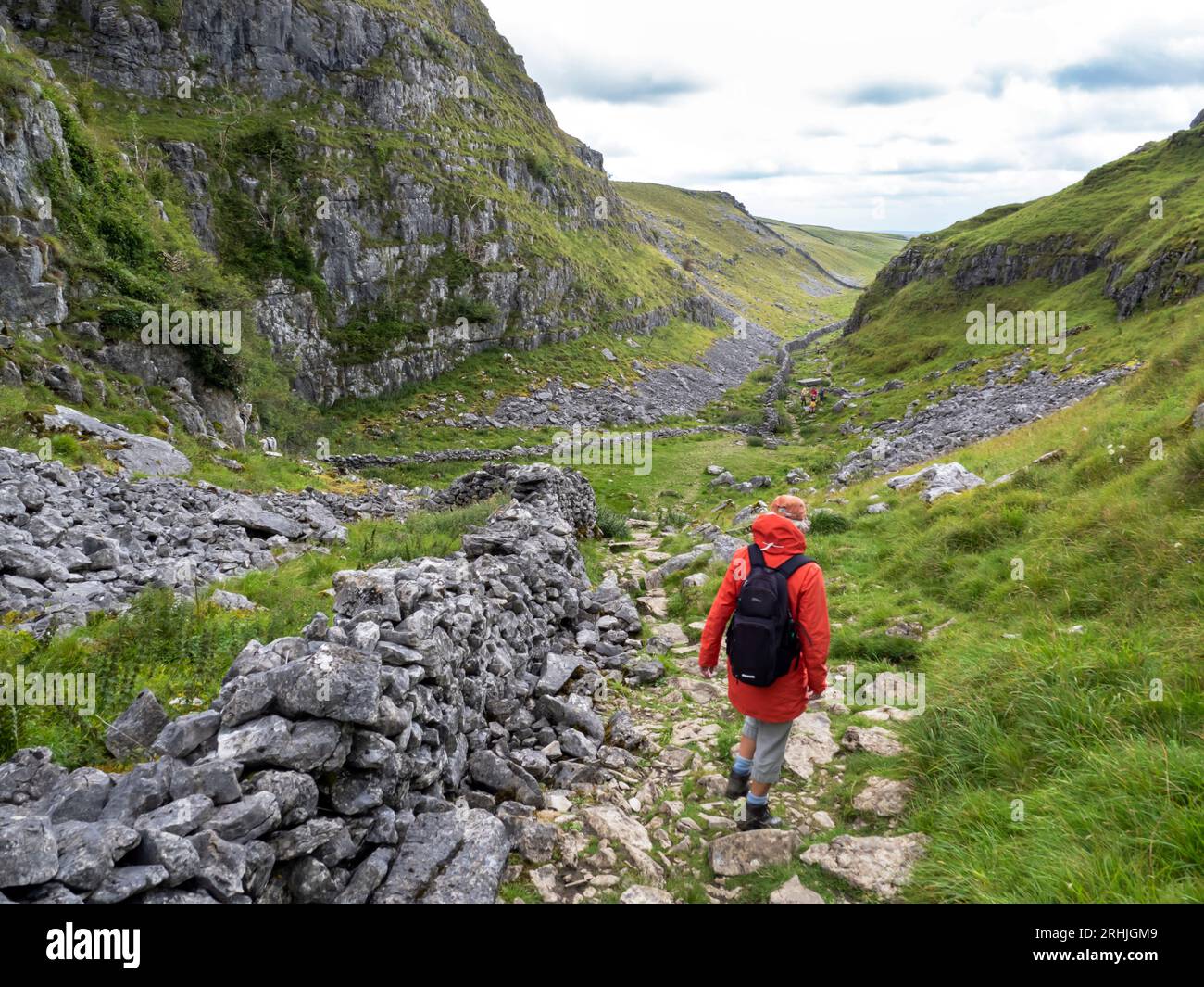 A woman walking down the dry valley of Ing Scar between Malham Tarn and ...