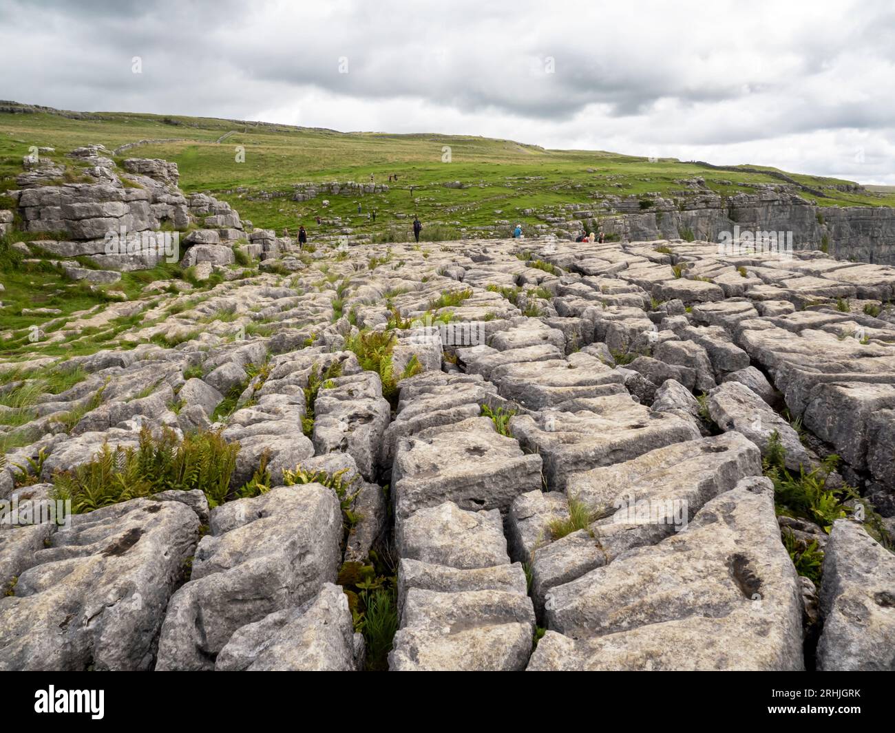 Walkers on limestone pavement at the top of Malham Cove, Yorkshire ...