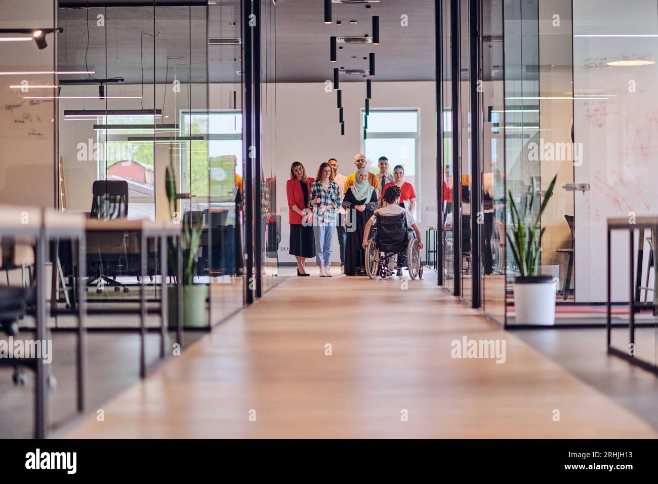 A diverse group of young business people congregates within a modern ...