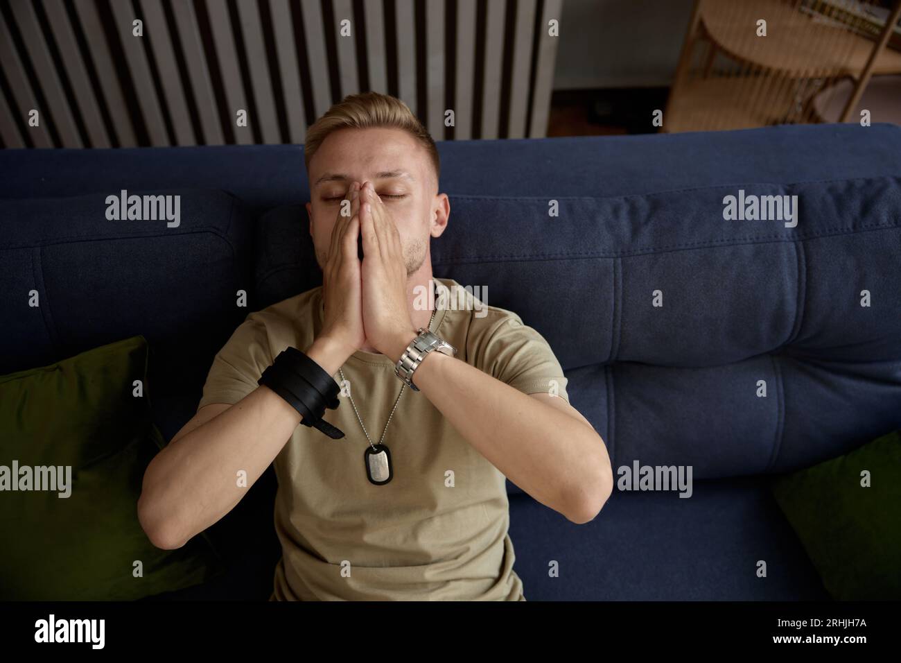 Depressed soldier suffering from military PTSD covering face with hands ...