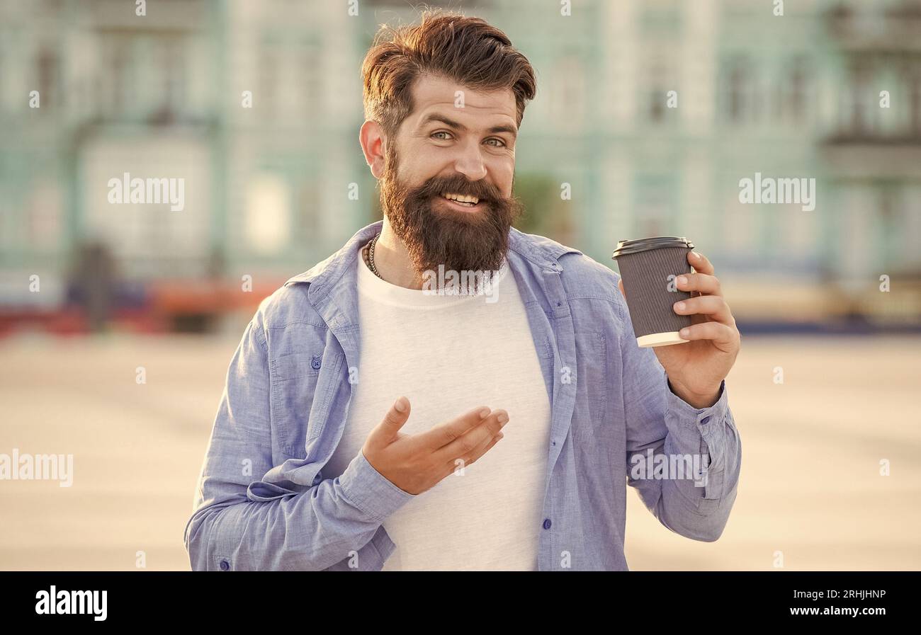 guy offering coffee in the street, presenting product. photo of guy ...