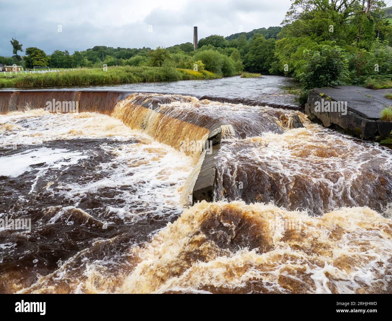 Peat stained water in the River Ribble going over a weir, after heavy ...