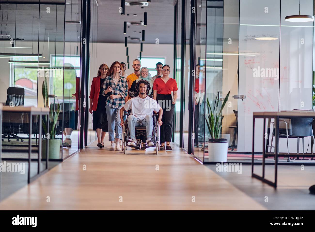 A diverse group of young business people congregates within a modern ...