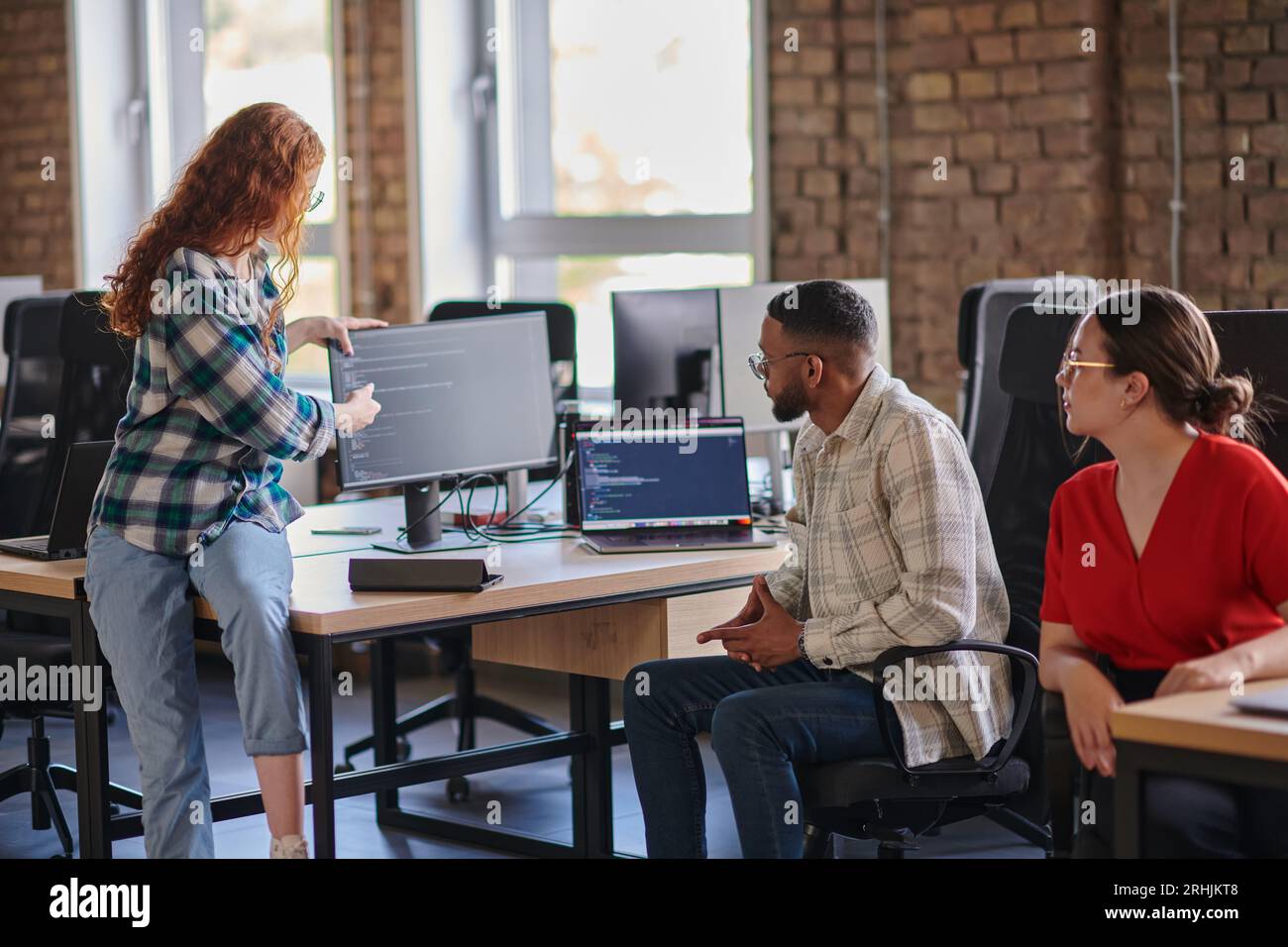 A diverse group of young business individuals congregates in a modern ...