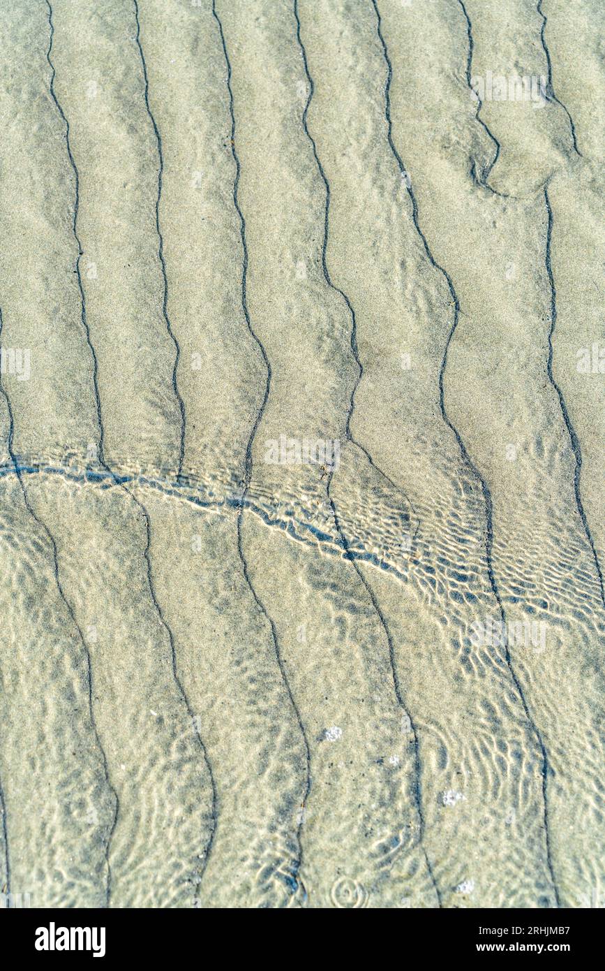 Ocean water forms patterns over sand as it reaches shore in Moclips ...