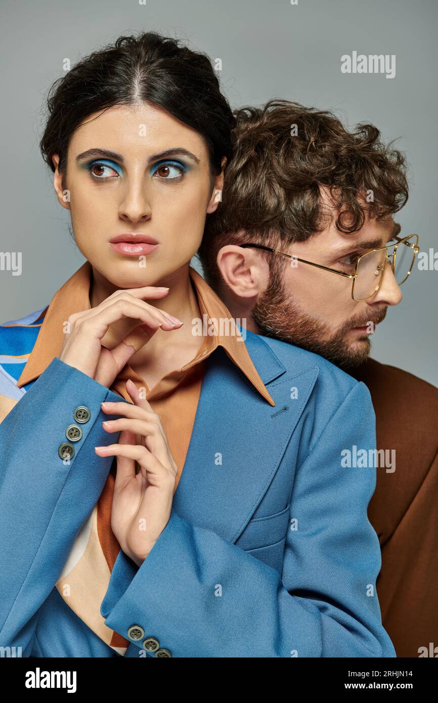 trendy couple posing on grey background, suits, elegant style, woman ...