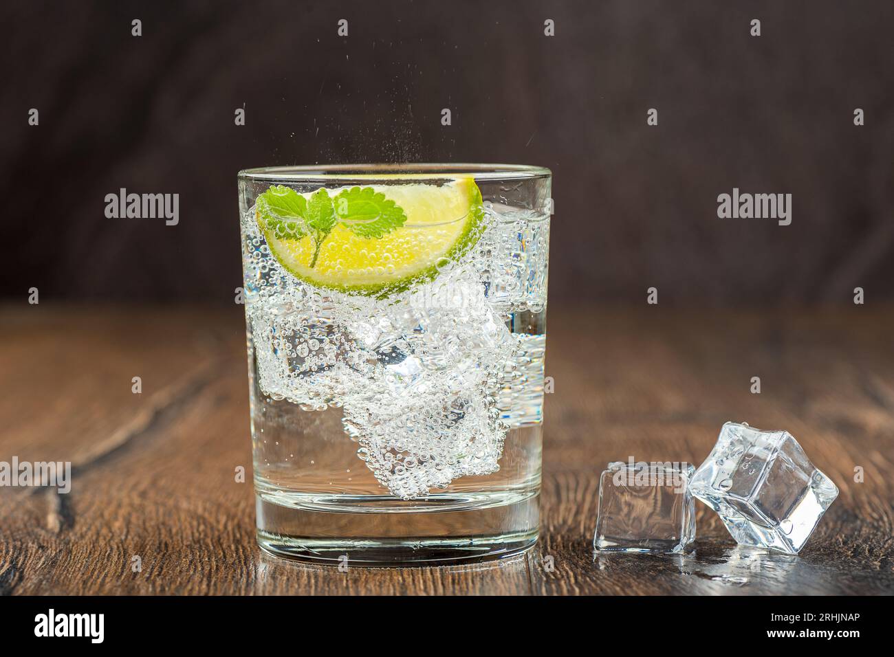 Cold, refreshing in the heat, sparkling water in a glass with ice cubes ...