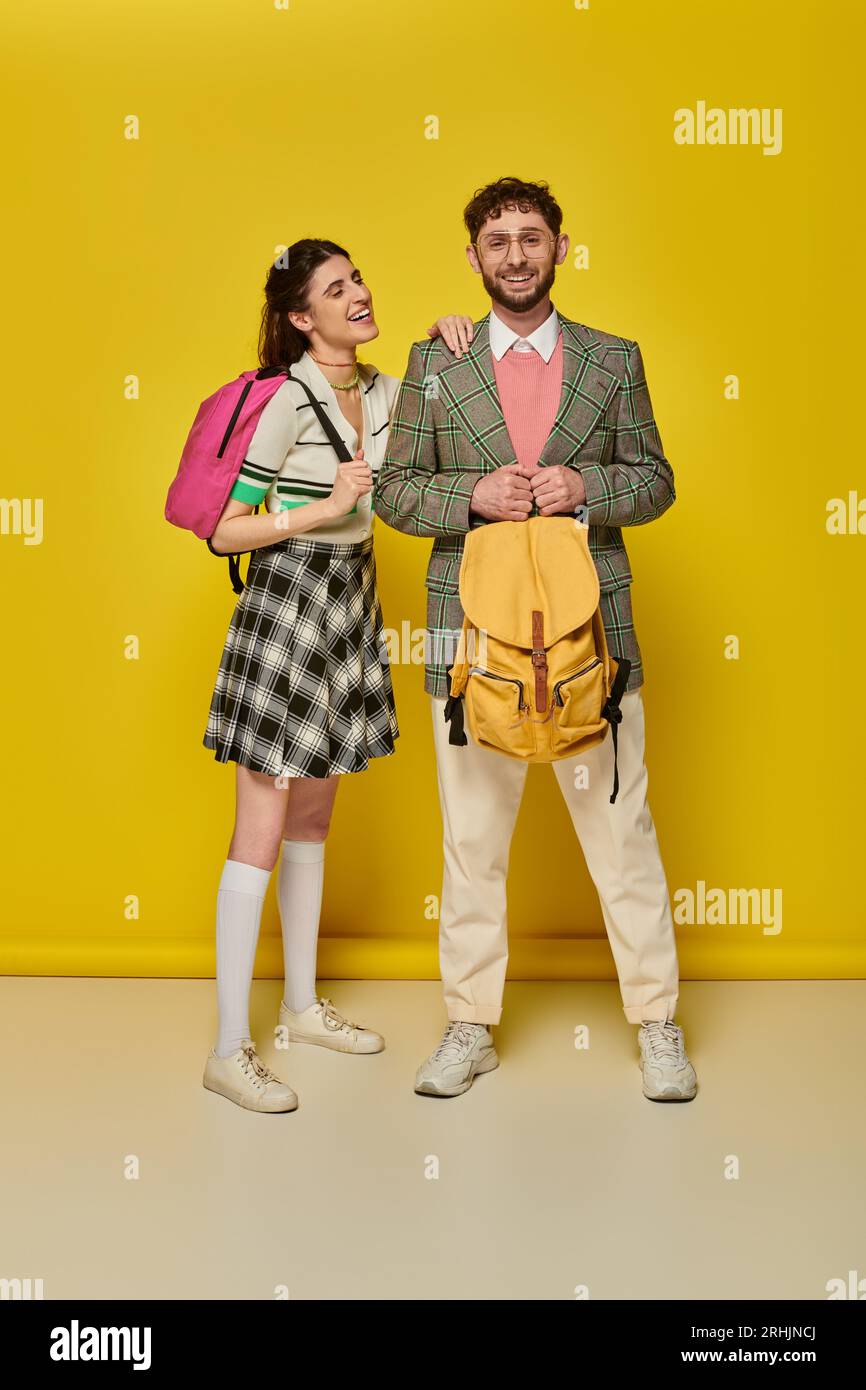 students standing with backpacks, looking at camera, smiling, yellow ...