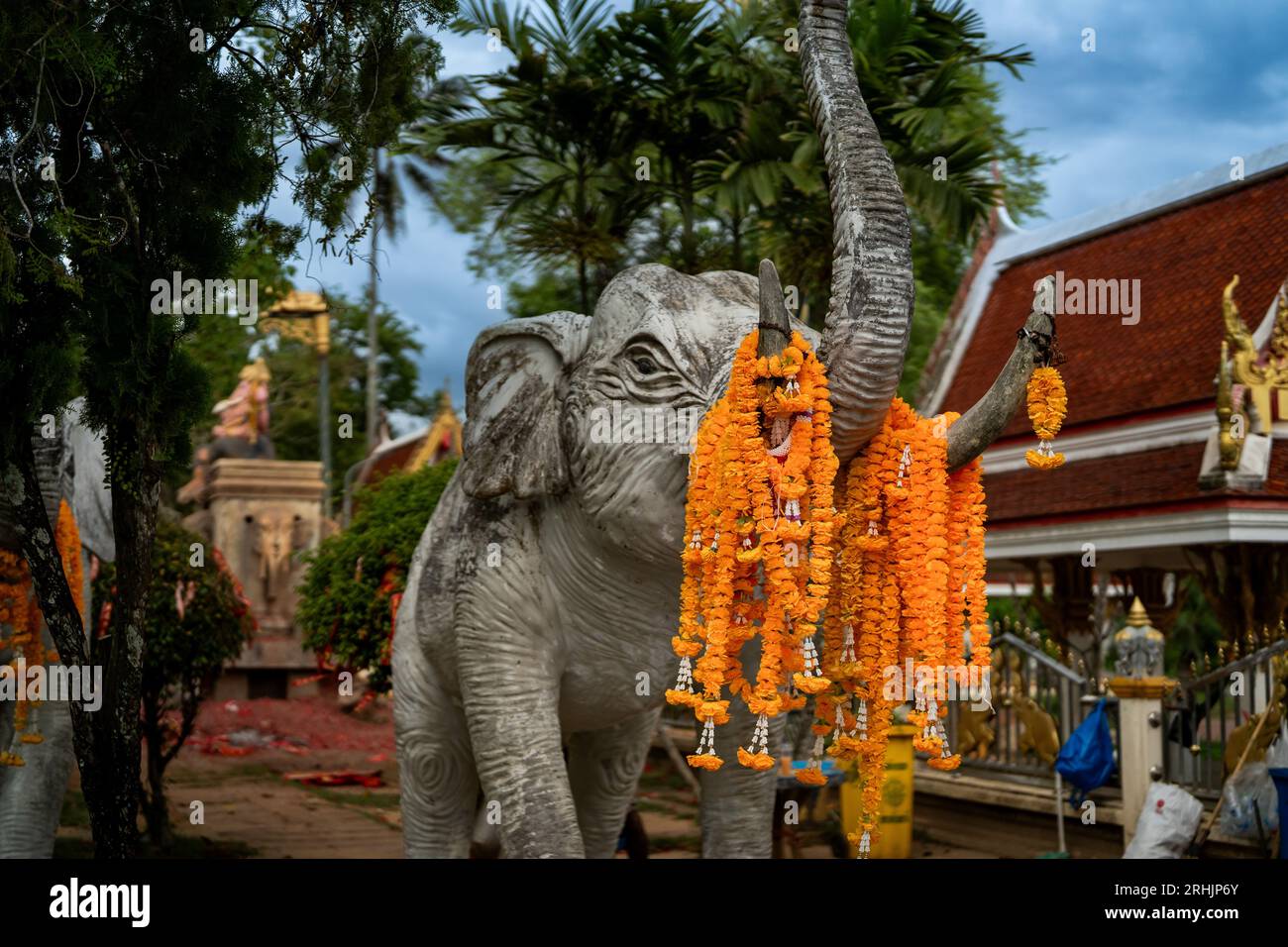 Marigold flower wreaths are seen placed on an elephant statue at Wat Na ...
