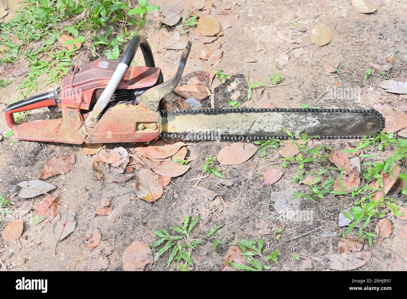 A portable gasoline Chainsaw put on the ground which is covered with a ...