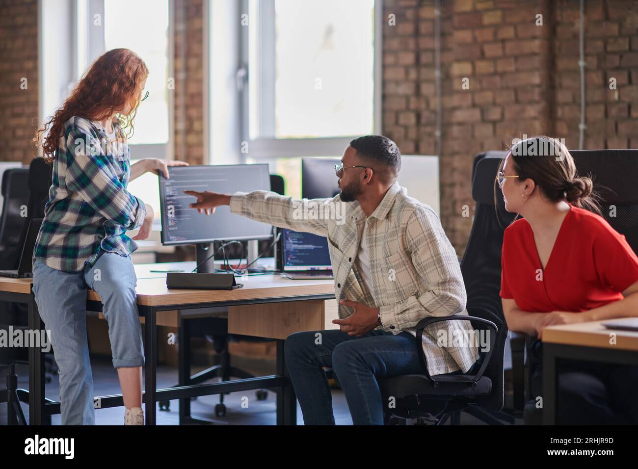 A diverse group of young business individuals congregates in a modern ...