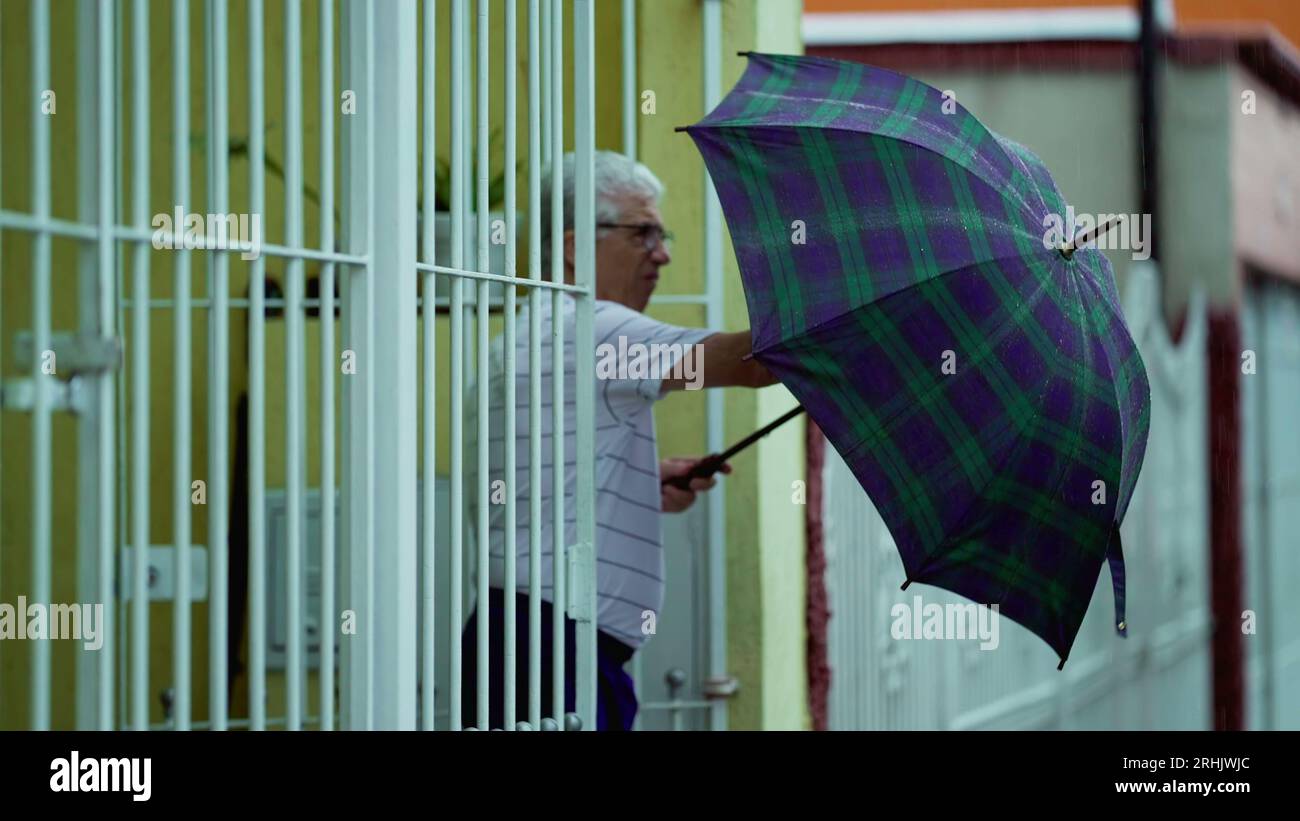 Older Man Steps Out in Rain, Opens Umbrella and Shuts Gate, Walks on ...
