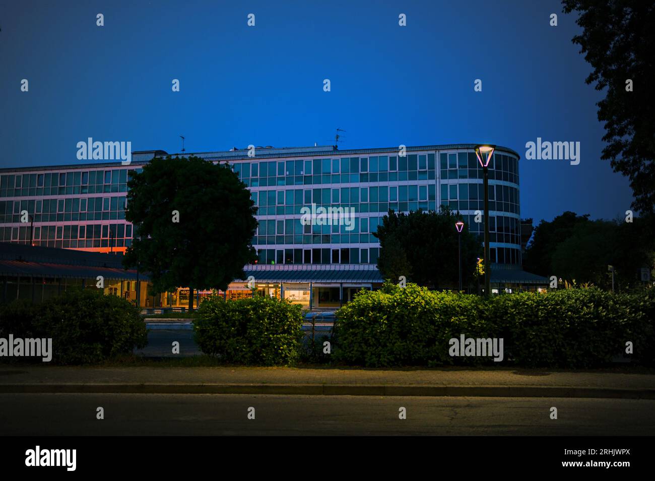 Big blue building with several windows (by night Stock Photo - Alamy