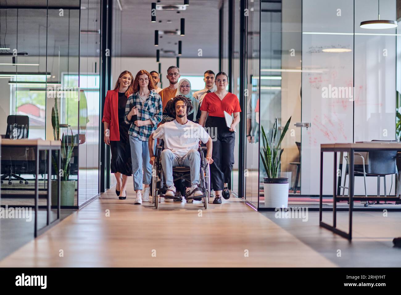 A diverse group of young business people congregates within a modern ...