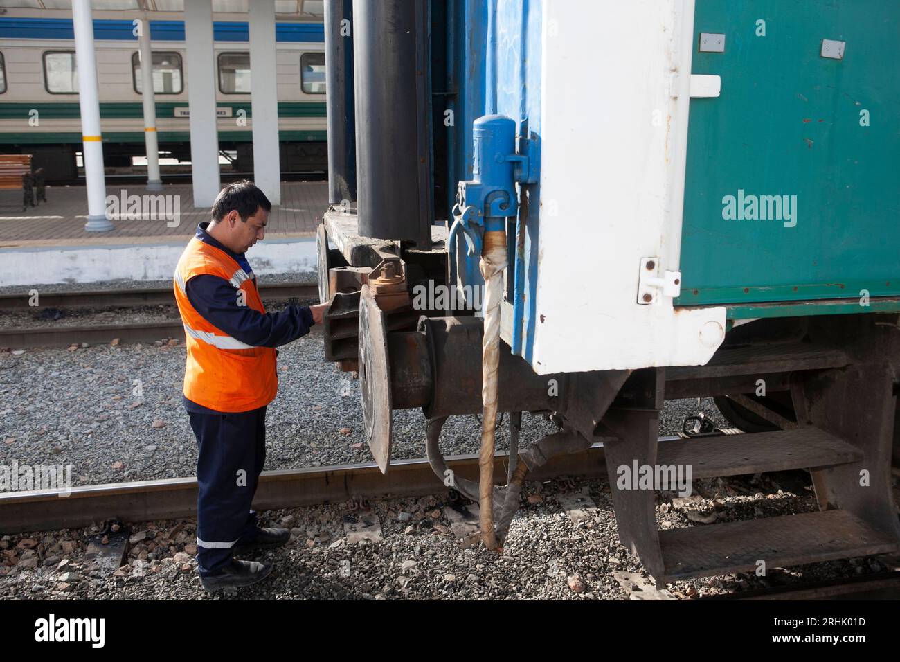 A worker checks a train coupling in Tashkent, Uzbekistan Stock Photo ...
