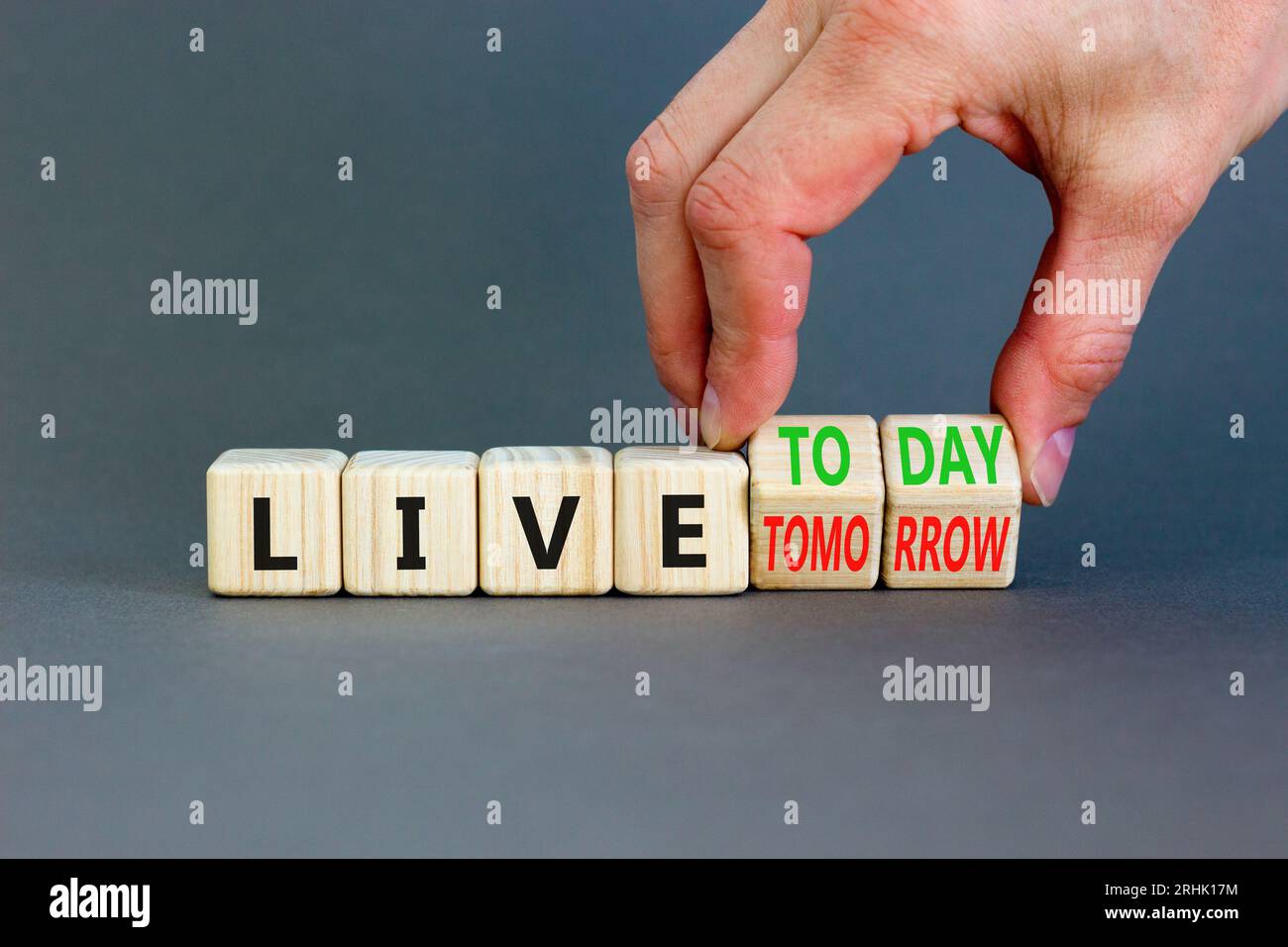 Live today not tomorrow symbol. Businessman turns wooden cubes and ...