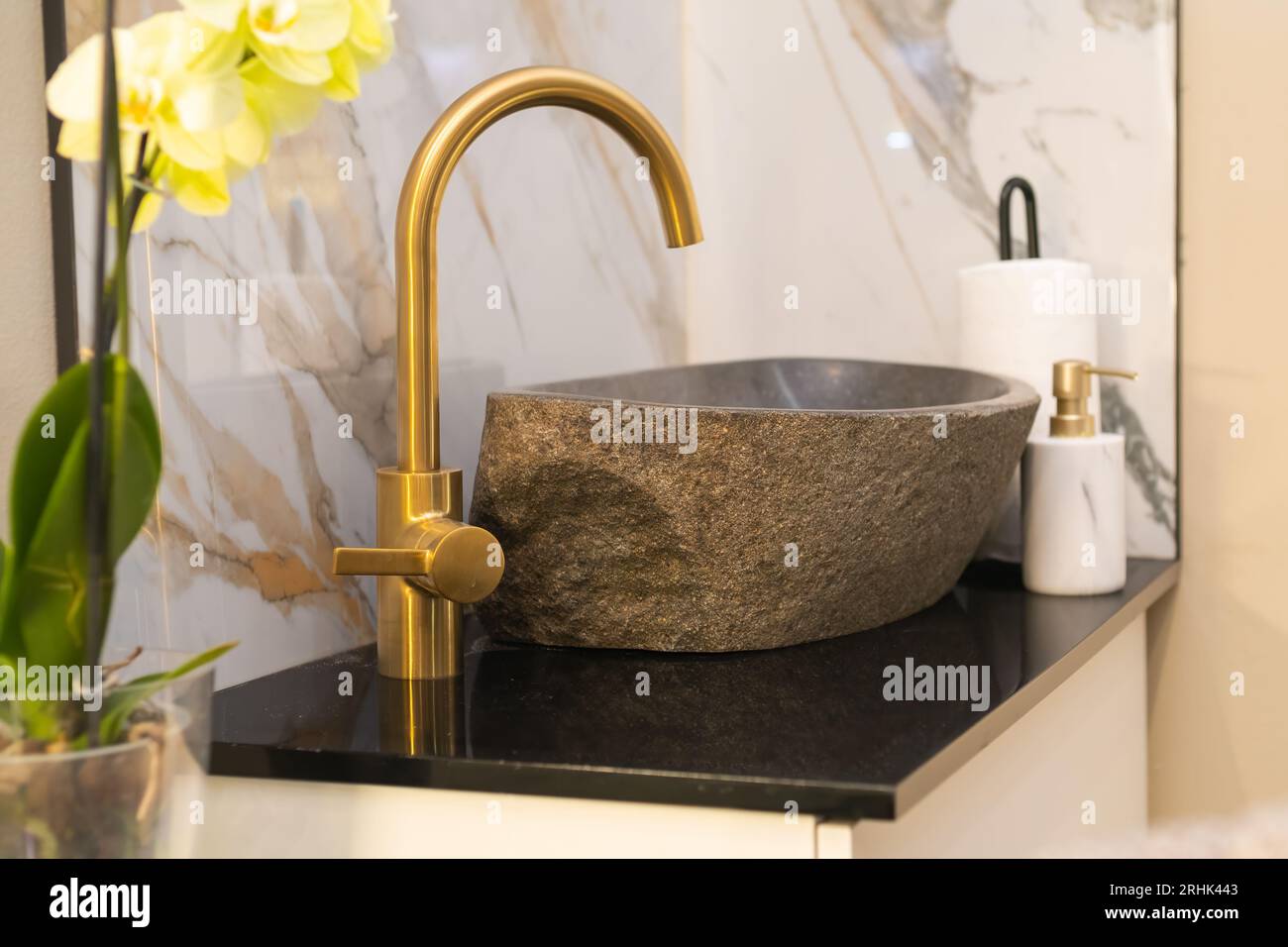 Stone washbasin and golden faucet. Modern interior design in a beauty ...