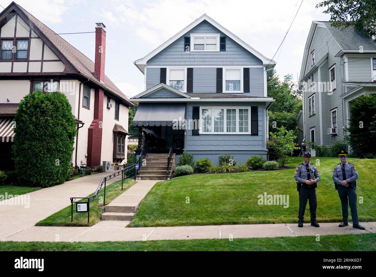 Officers stand outside President Joe Biden's childhood home, center, as ...