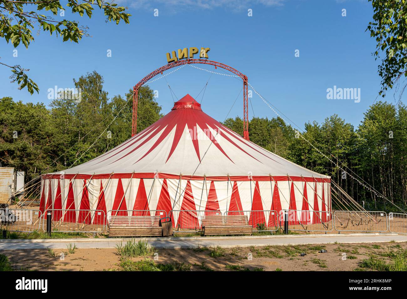 the red and white striped tent of the traveling circus is installed in ...