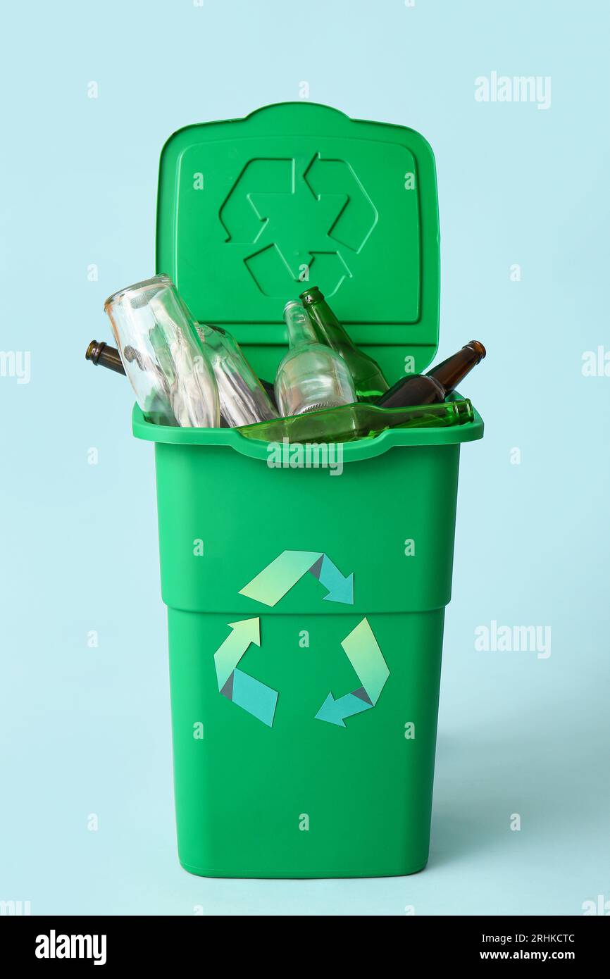 Container for garbage with glass bottles on light blue background ...