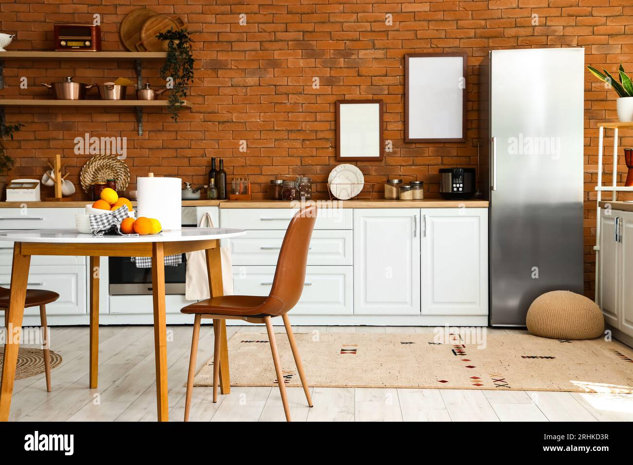 Interior of kitchen with stylish fridge, counters, shelves, table and ...