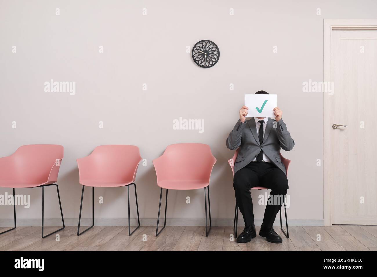 Male applicant holding paper sheet with check mark in room Stock Photo ...