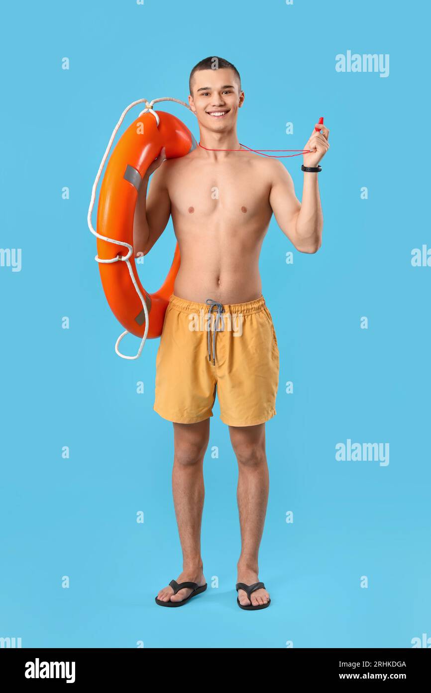 Male lifeguard with ring buoy and whistle on blue background Stock ...