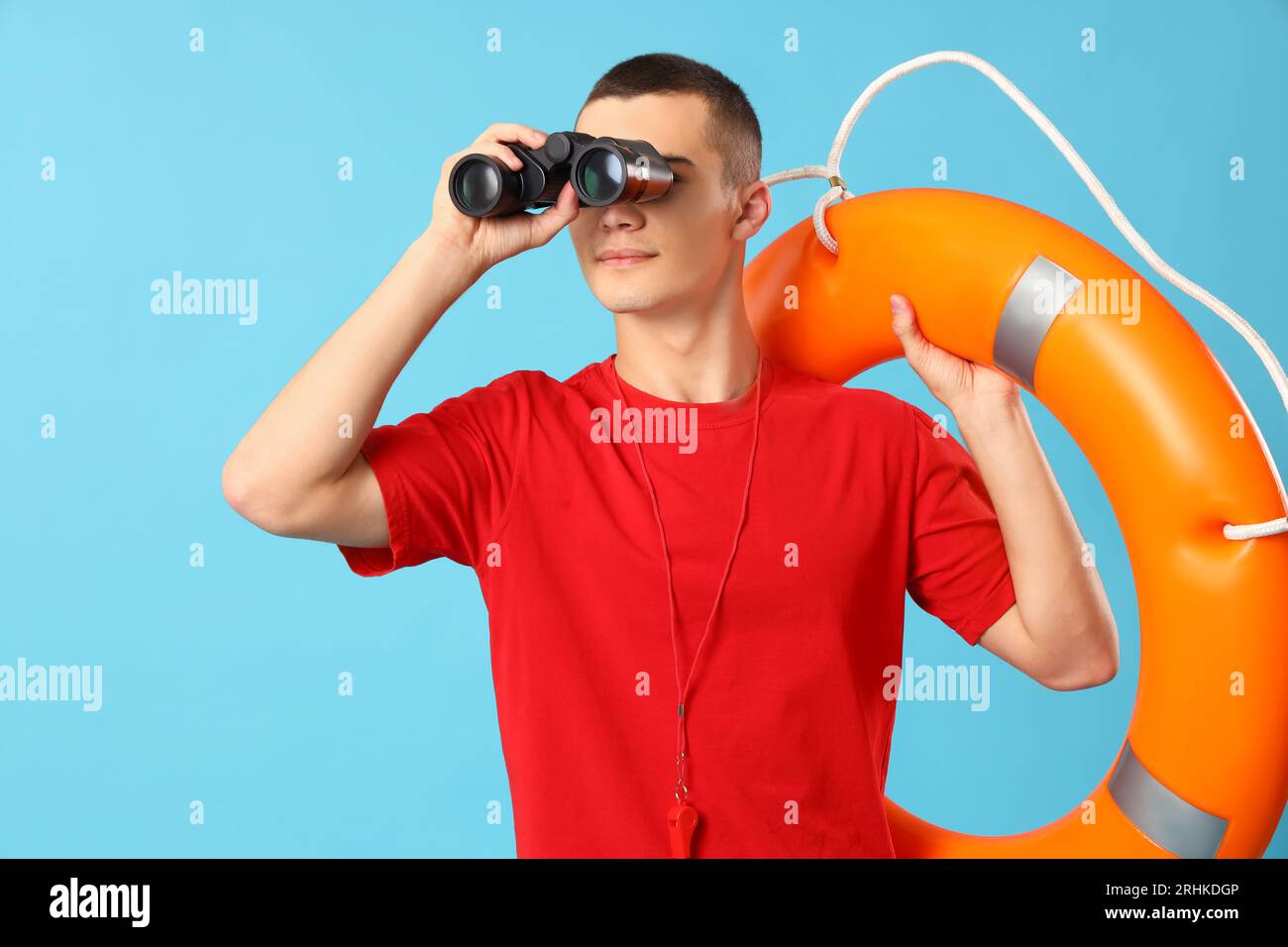 Male lifeguard with binoculars and ring buoy on blue background Stock ...