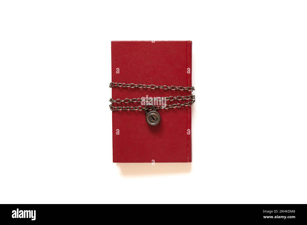 Red book on a chain under lock and key on a white background close-up ...