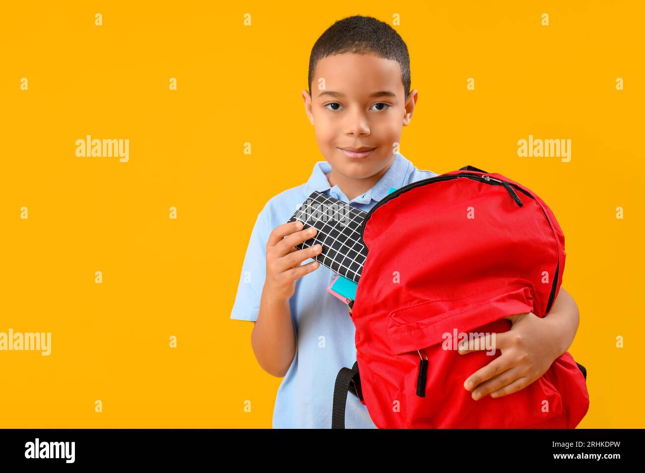 Little African-American schoolboy with pencil case and backpack on ...