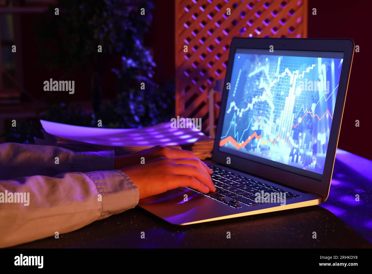 Female programmer typing on laptop keyboard at night in office, closeup ...