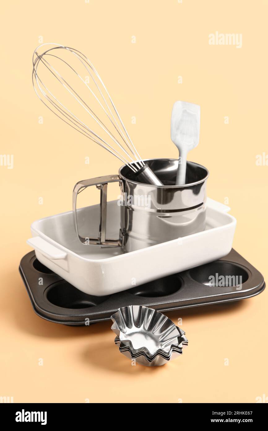 Baking forms and utensils on beige background Stock Photo - Alamy