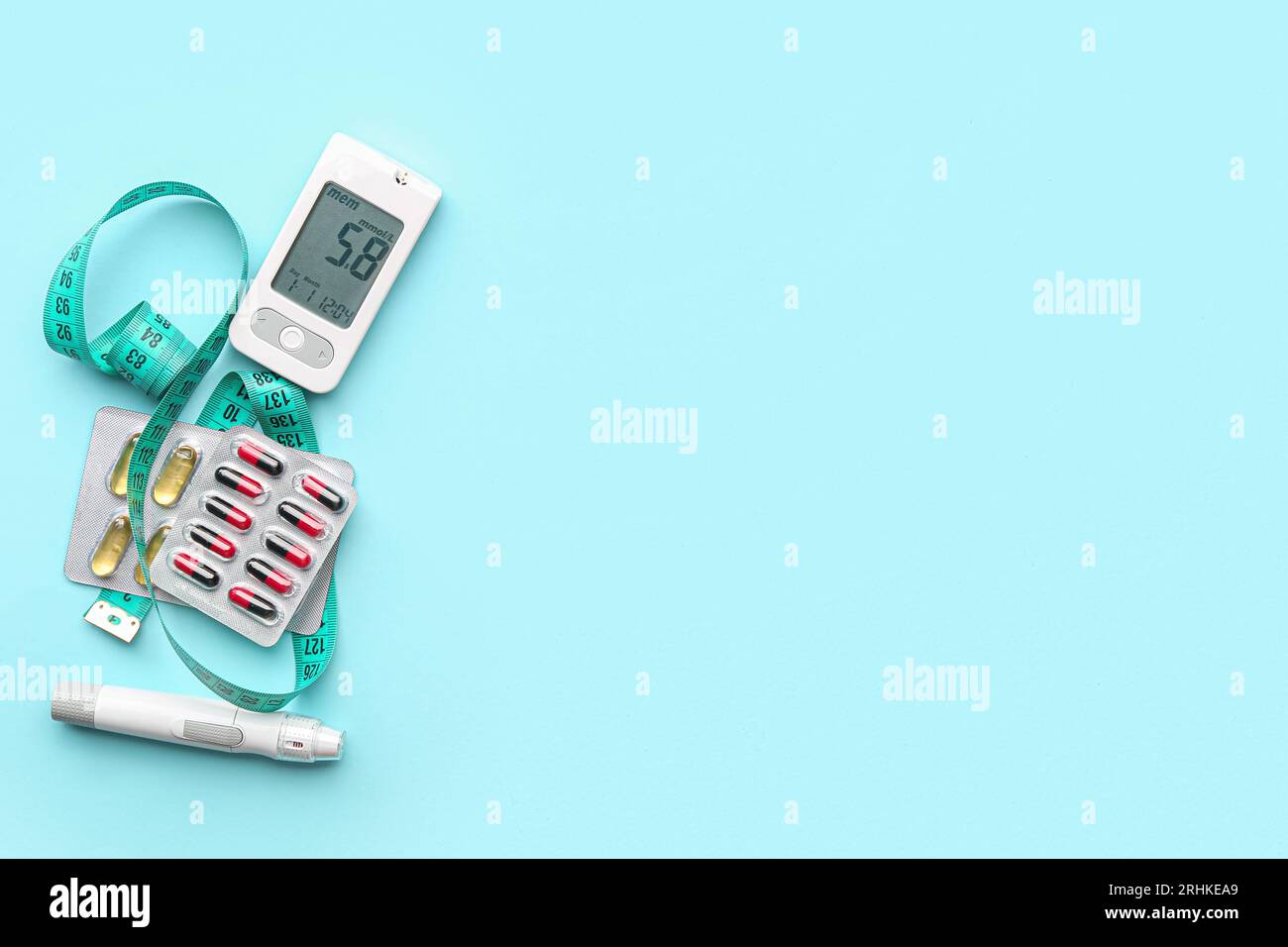 Glucometer with tape measure, pills and lancet pen on blue background ...