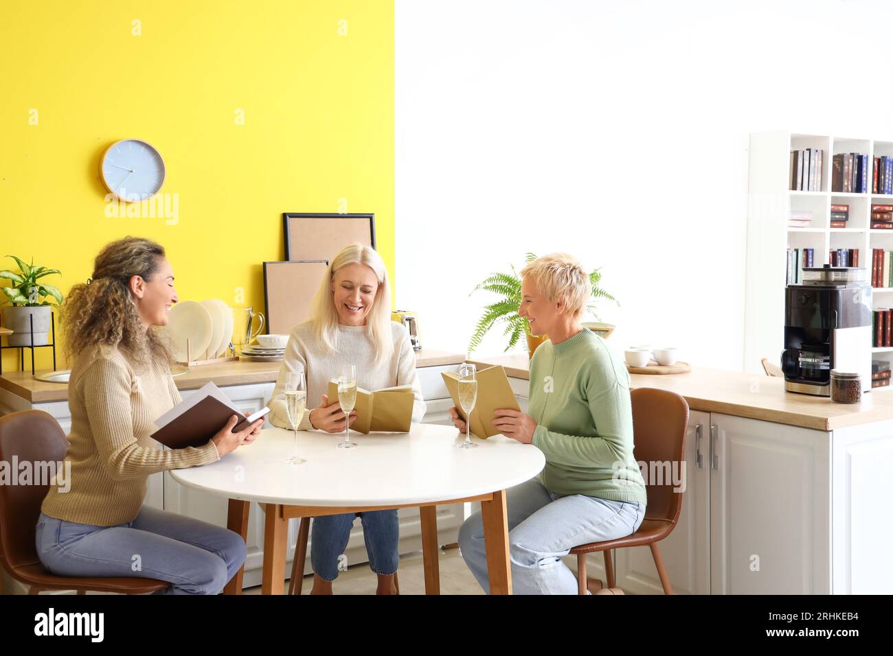 Mature women with champagne taking part in book club at home Stock ...