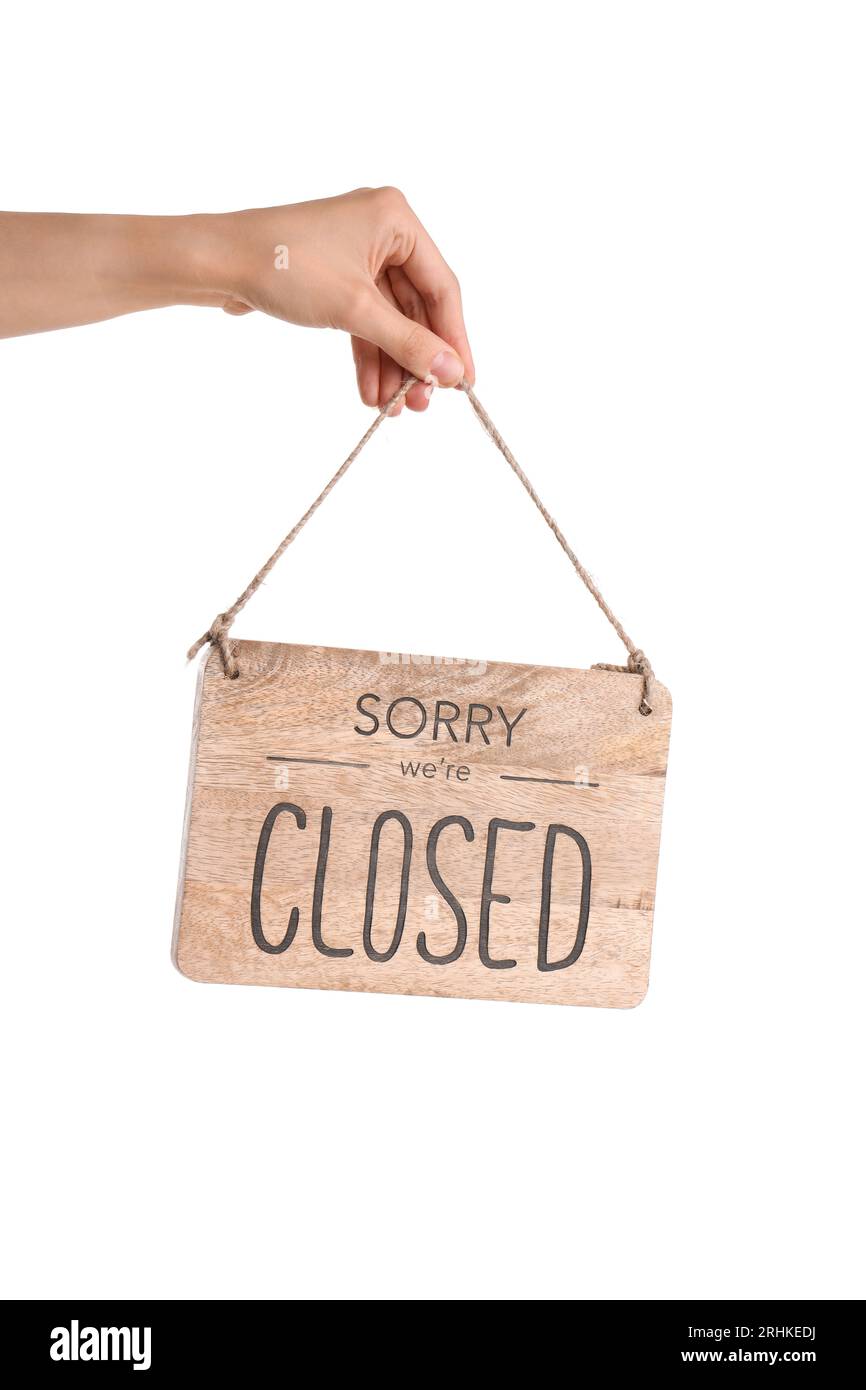 Female hand holding sign with text SORRY WE'RE CLOSED on white ...