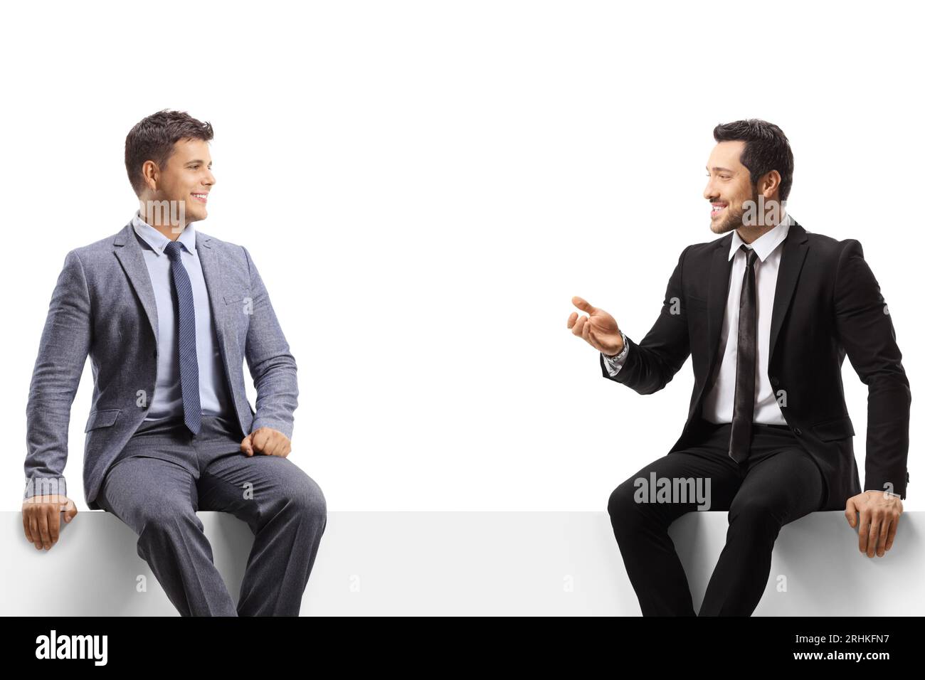 Businessmen sitting on a blank panel and having a conversation isolated ...