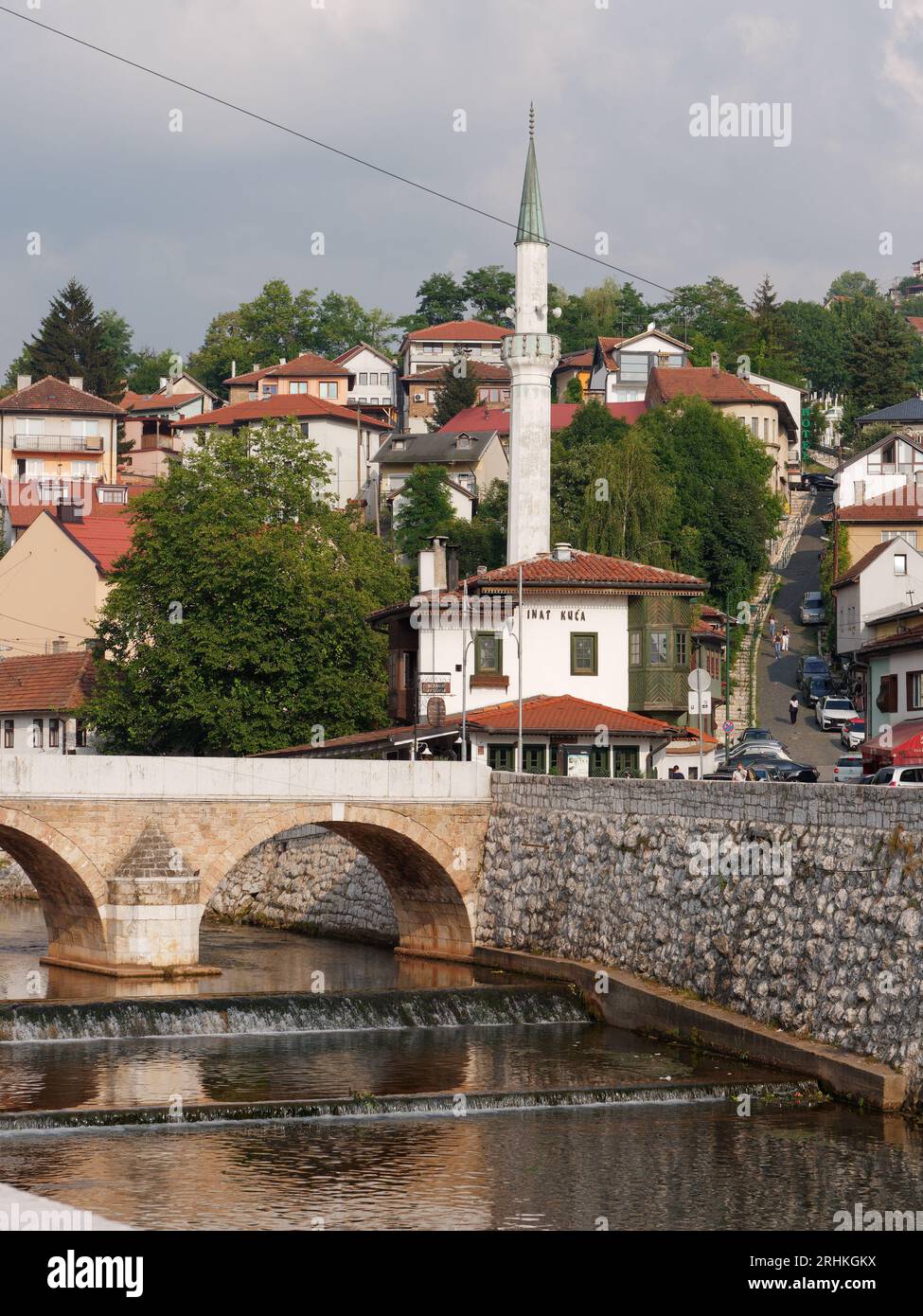 bridge over the Miljacka river with Inat Kuca restaurant and minaret ...