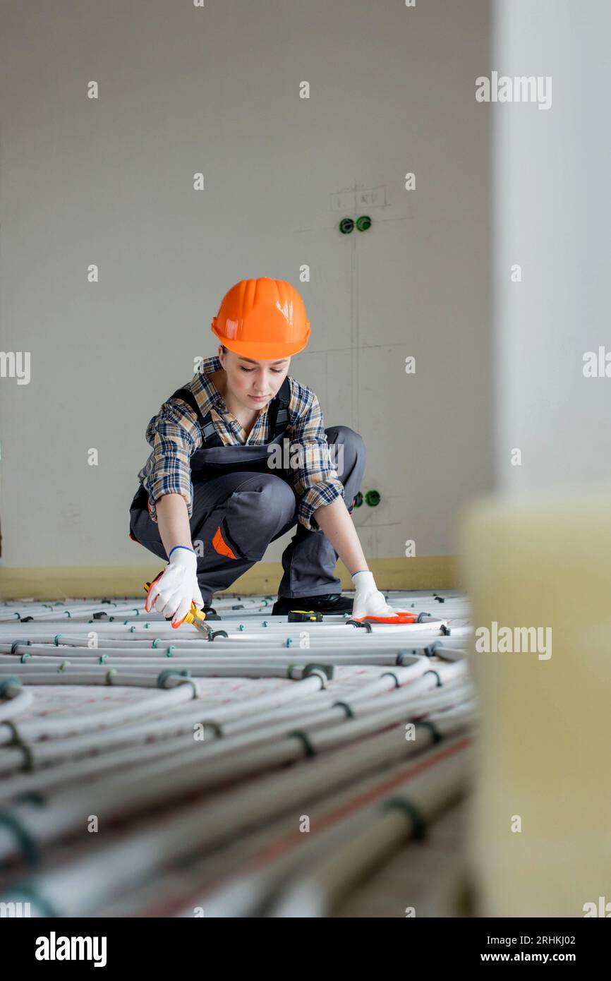 Woman worker is installing underfloor heating system. Warm floor ...