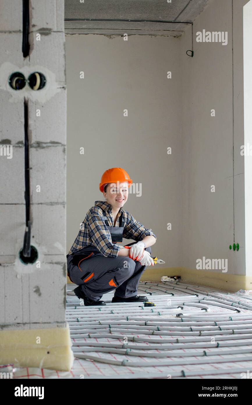 Portrait of woman worker which is installing underfloor heating system ...