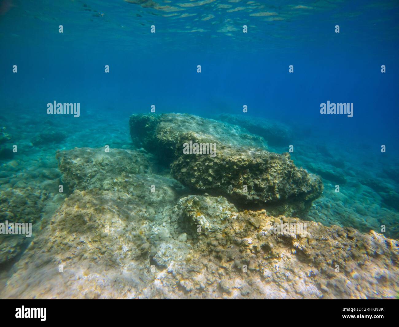 Large rock fragments in the clear sea. Underwater view of the Aegean ...