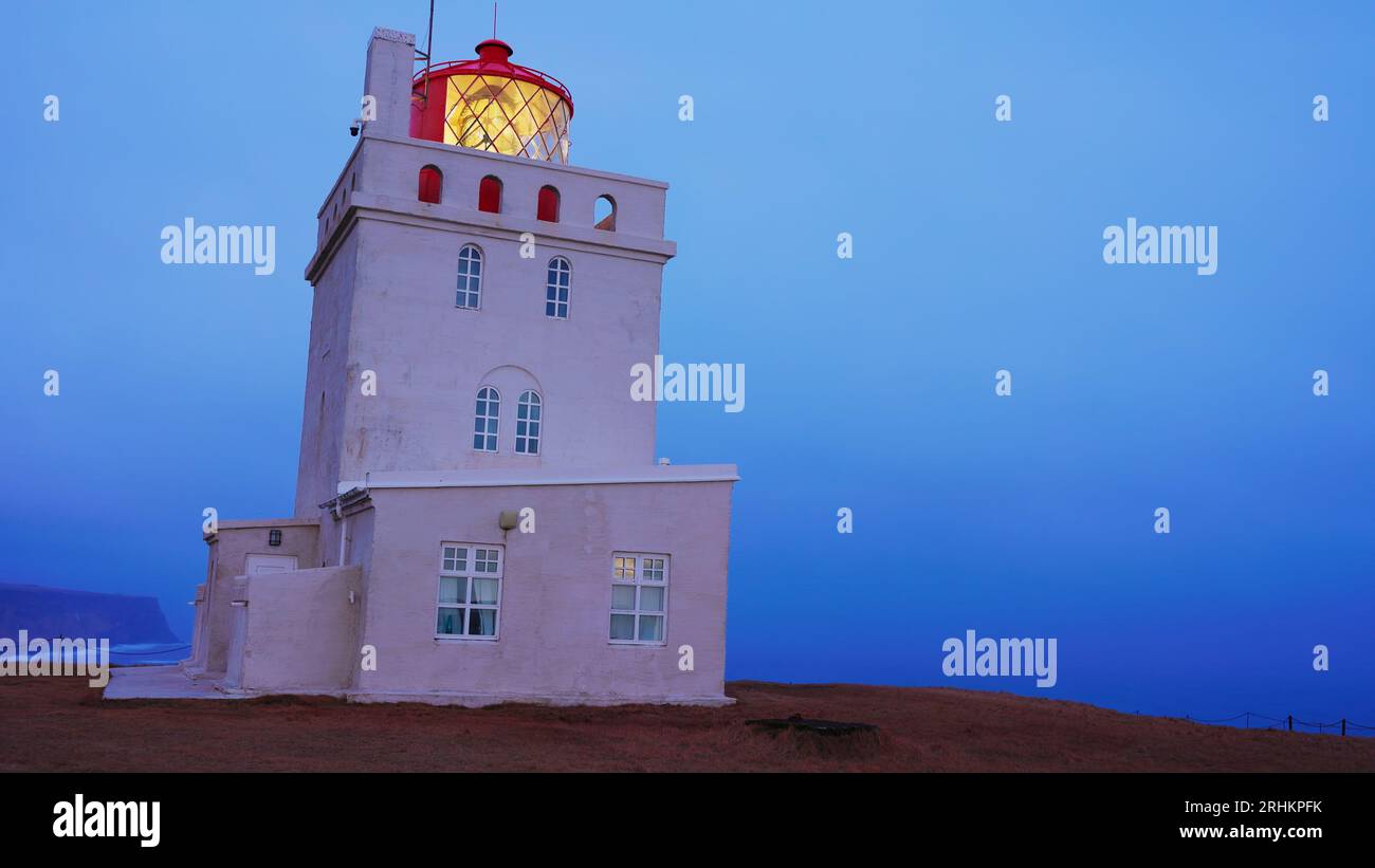 Dyrholaey lighthouse on arctic coastline, beautiful old building with ...