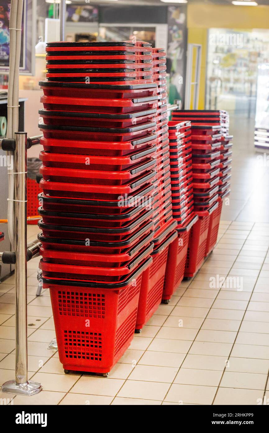 stacked empty red plastic grocery baskets in a mall Stock Photo - Alamy