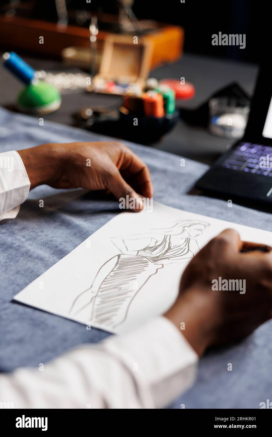 Close up of meticulous couturier drawing stylish dress from upcoming ...