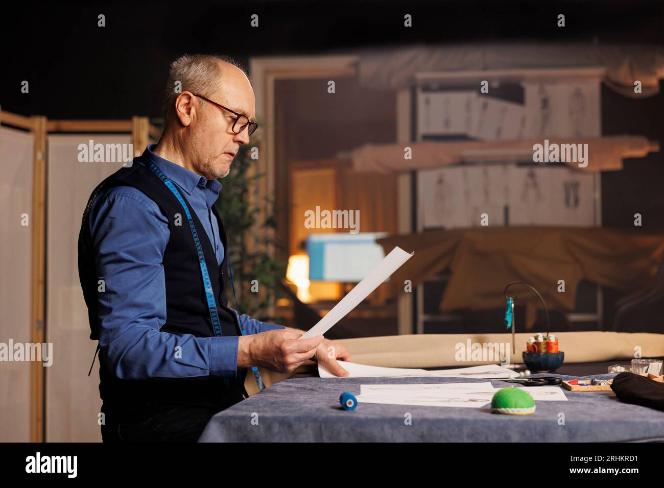 Dressmaker looking over sketch drawings, preparing to manufacture ...