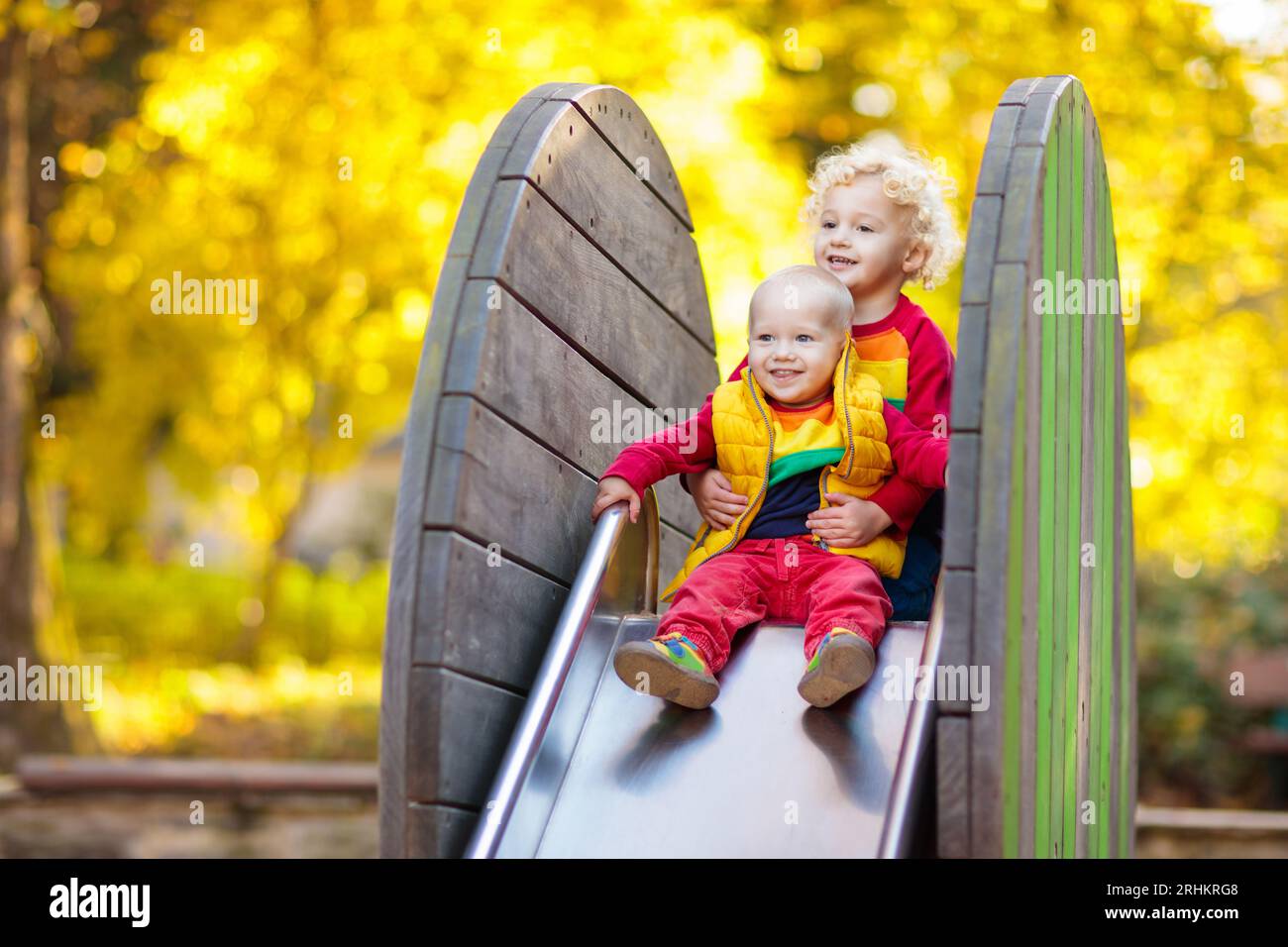 Kids on playground Children play in autumn park. Child on slide and ...