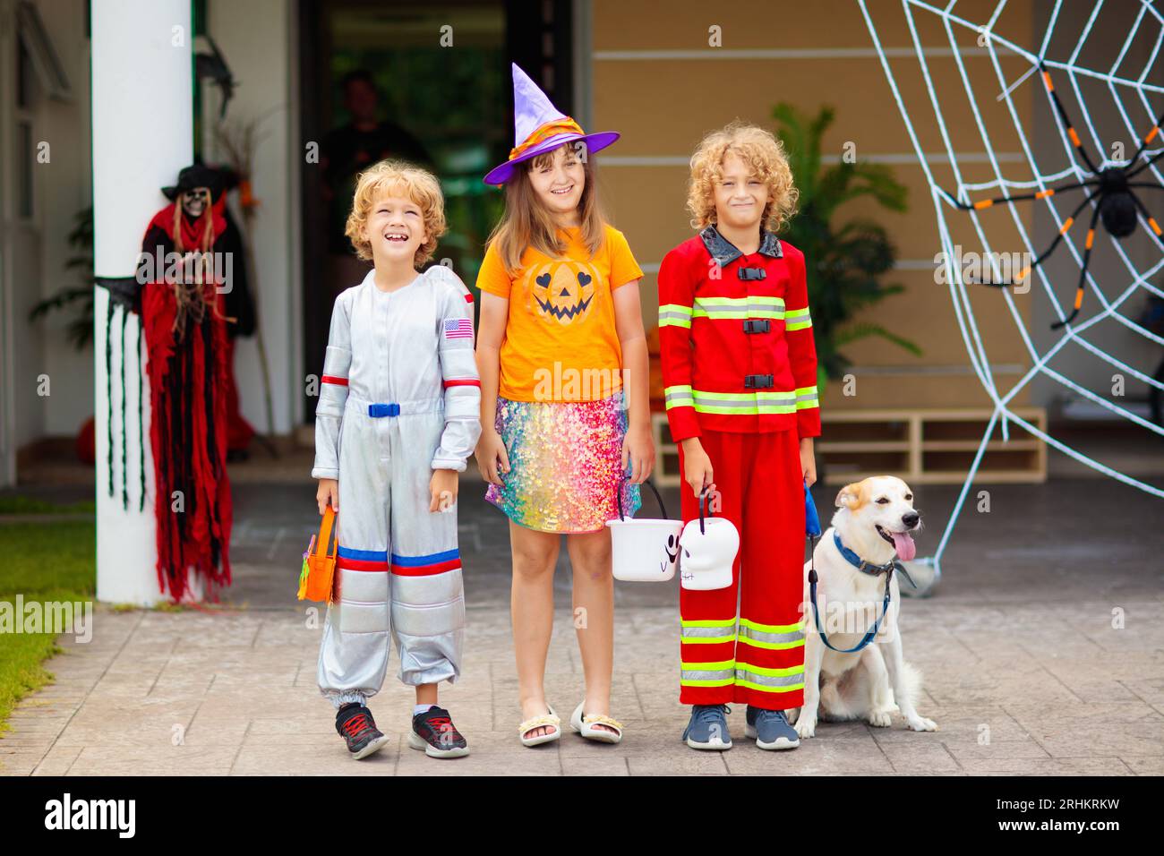 Kids trick or treat on Halloween night. Dressed up children at ...