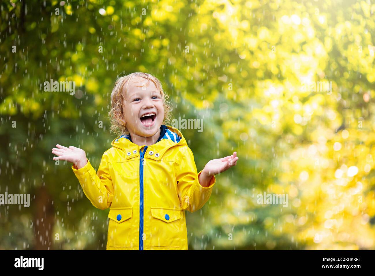 Kids play in autumn rain. Child playing outdoor on rainy day. Little ...